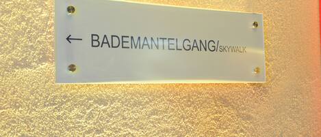 Um sinal com o texto 'BADEMANTELGANG/skywalk' e uma seta apontando para a esquerda.