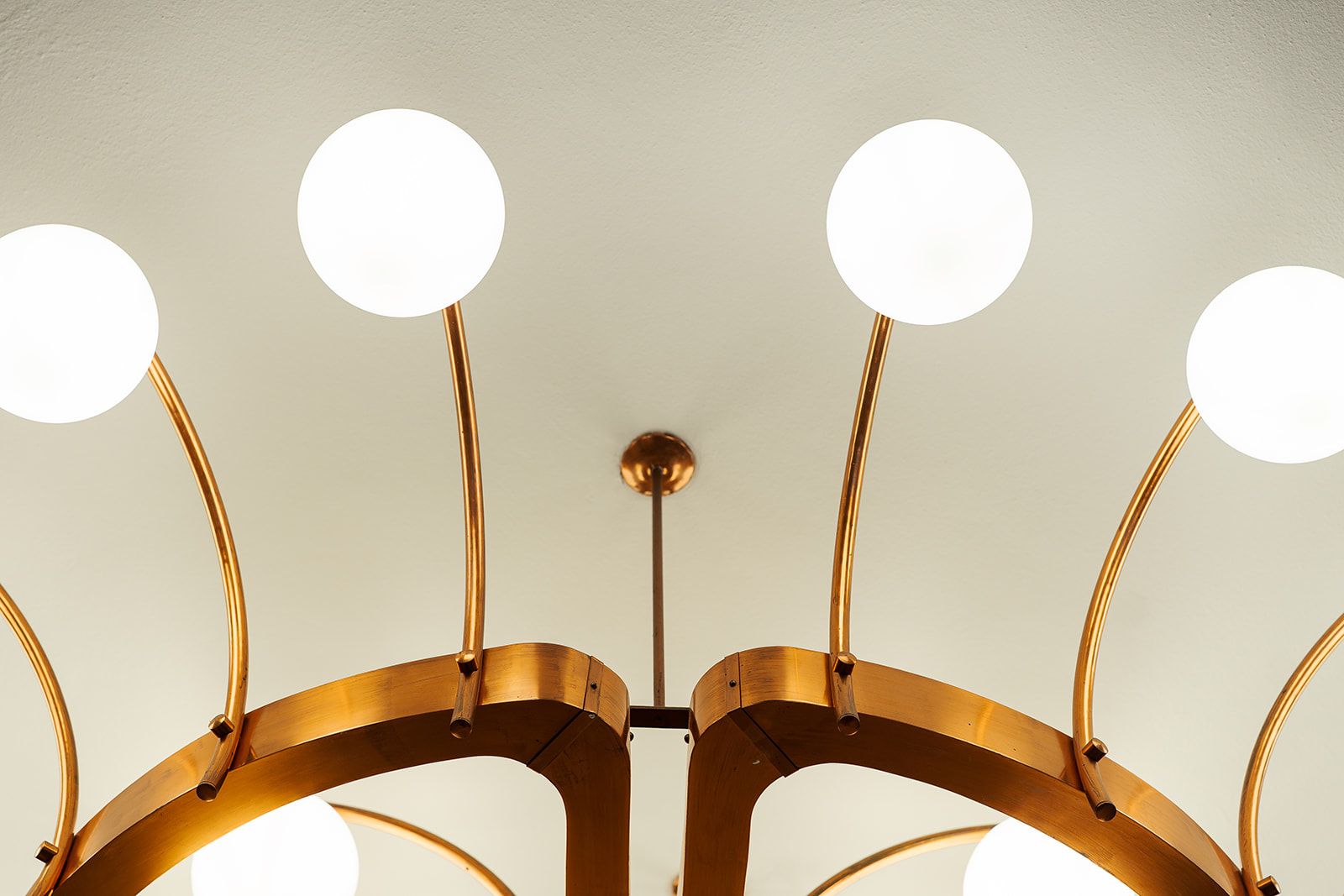 Teto com luminária central e quatro luzes pendentes esféricas.