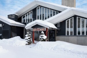 Um edifício com placa de pub e bistro, rodeado de neve.