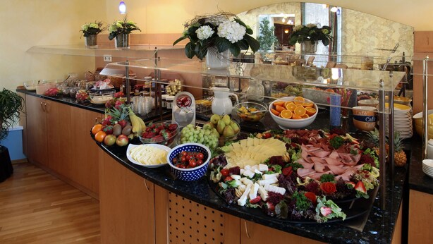 Buffet com diversos alimentos e uma vitrine de vidro.