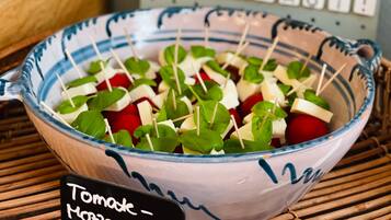 Uma saladeira com tomate, mussarela e espinafre, com um letreiro indicando os ingredientes.