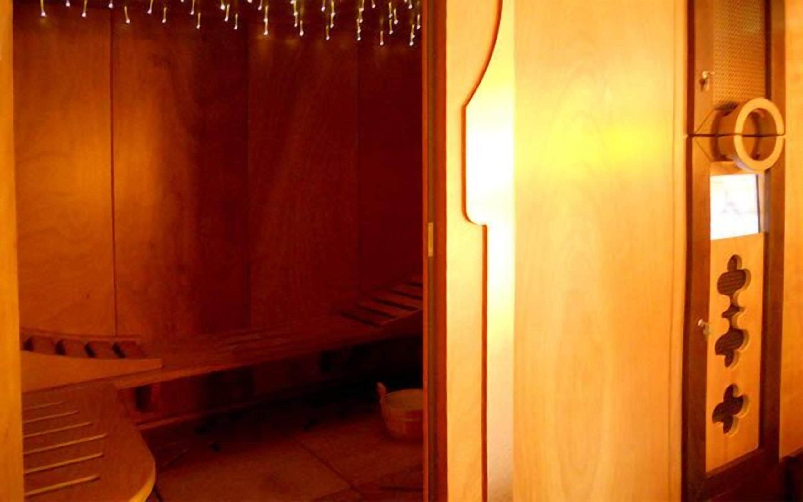 Uma sala de sauna de madeira com bancos e um banco com toalha.