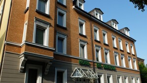Um hotel de vários andares com fachada de tijolo e molduras de janela brancas.