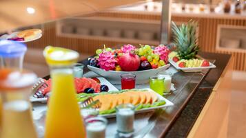 Um buffet com diversas frutas, legumes e bebidas.