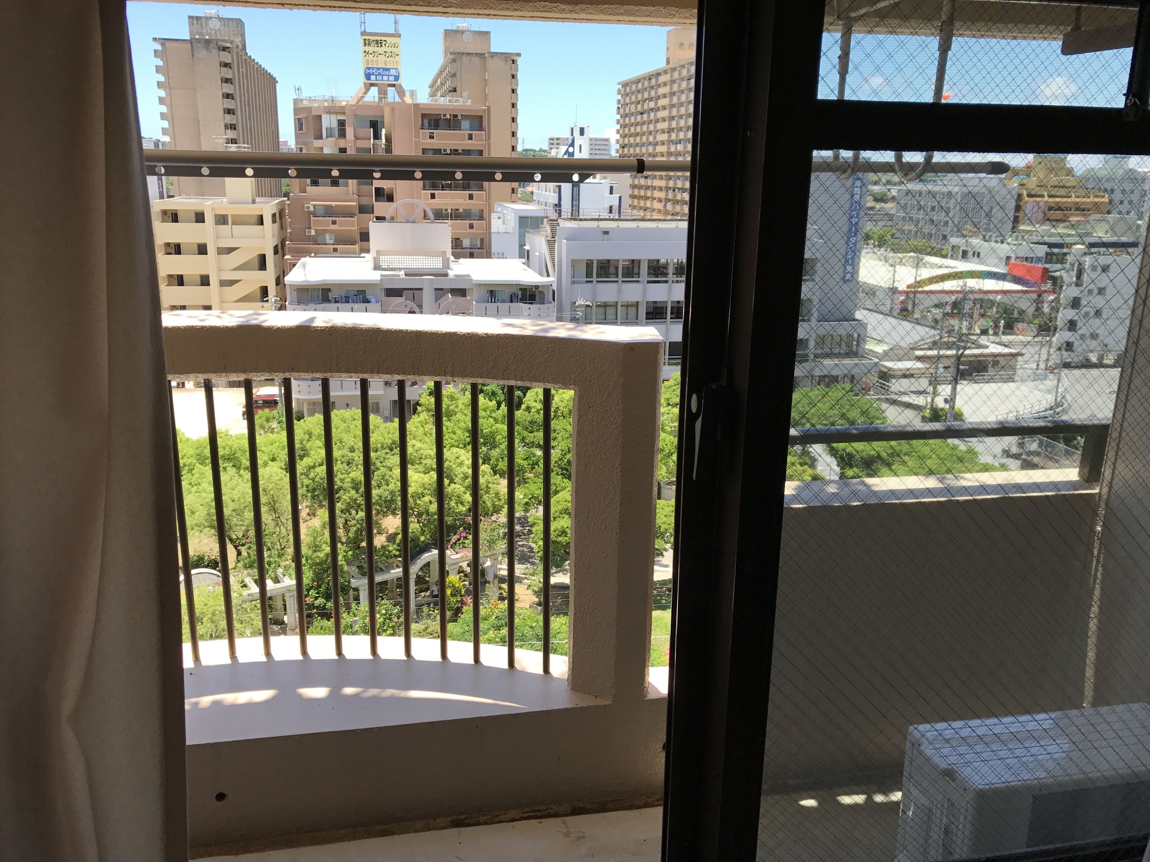 Varanda com vista para edifícios urbanos e áreas verdes.