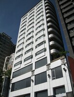 Um edifício alto e moderno, com vários andares e grandes janelas.