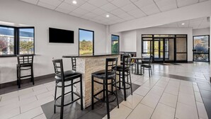 Um espaço amplo e moderno para bar, com teto alto, grandes janelas com vista para o exterior e design limpo e minimalista.