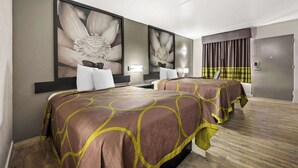 Quarto de hotel com duas camas, uma grande obra de arte floral na parede e design moderno.