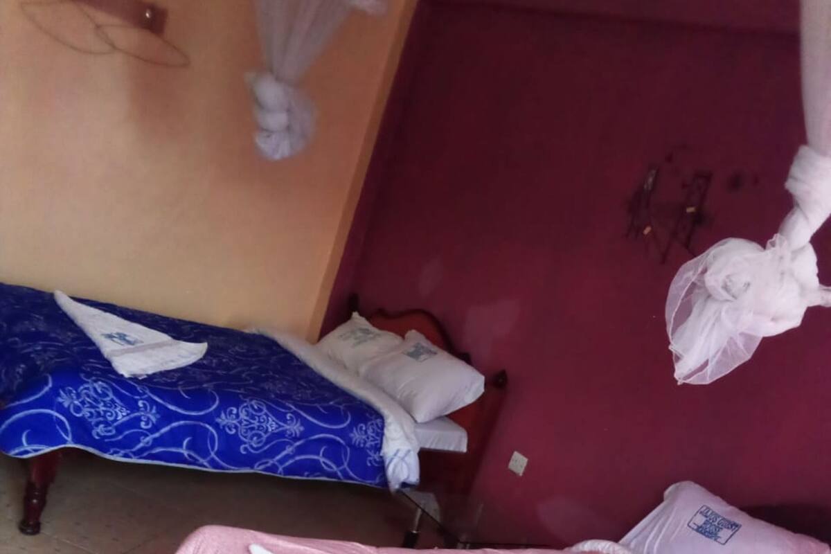 Quarto com duas camas, uma com colcha azul e outra com colcha rosa.
