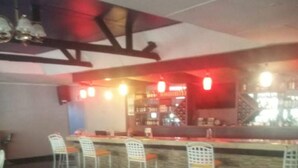 Uma área de bar com balcão e várias cadeiras.