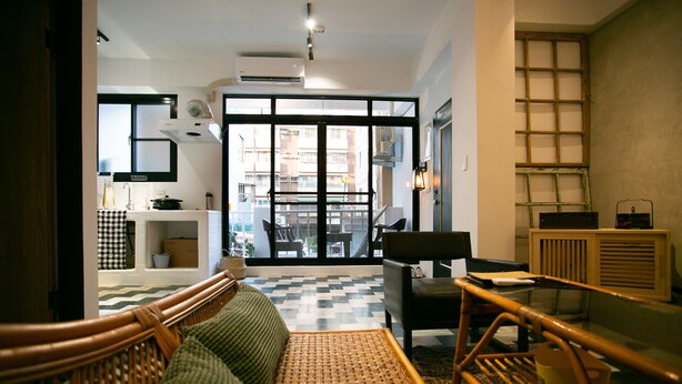 Uma sala de estar moderna com uma grande janela, um sofá, uma mesa de centro e uma área de jantar.