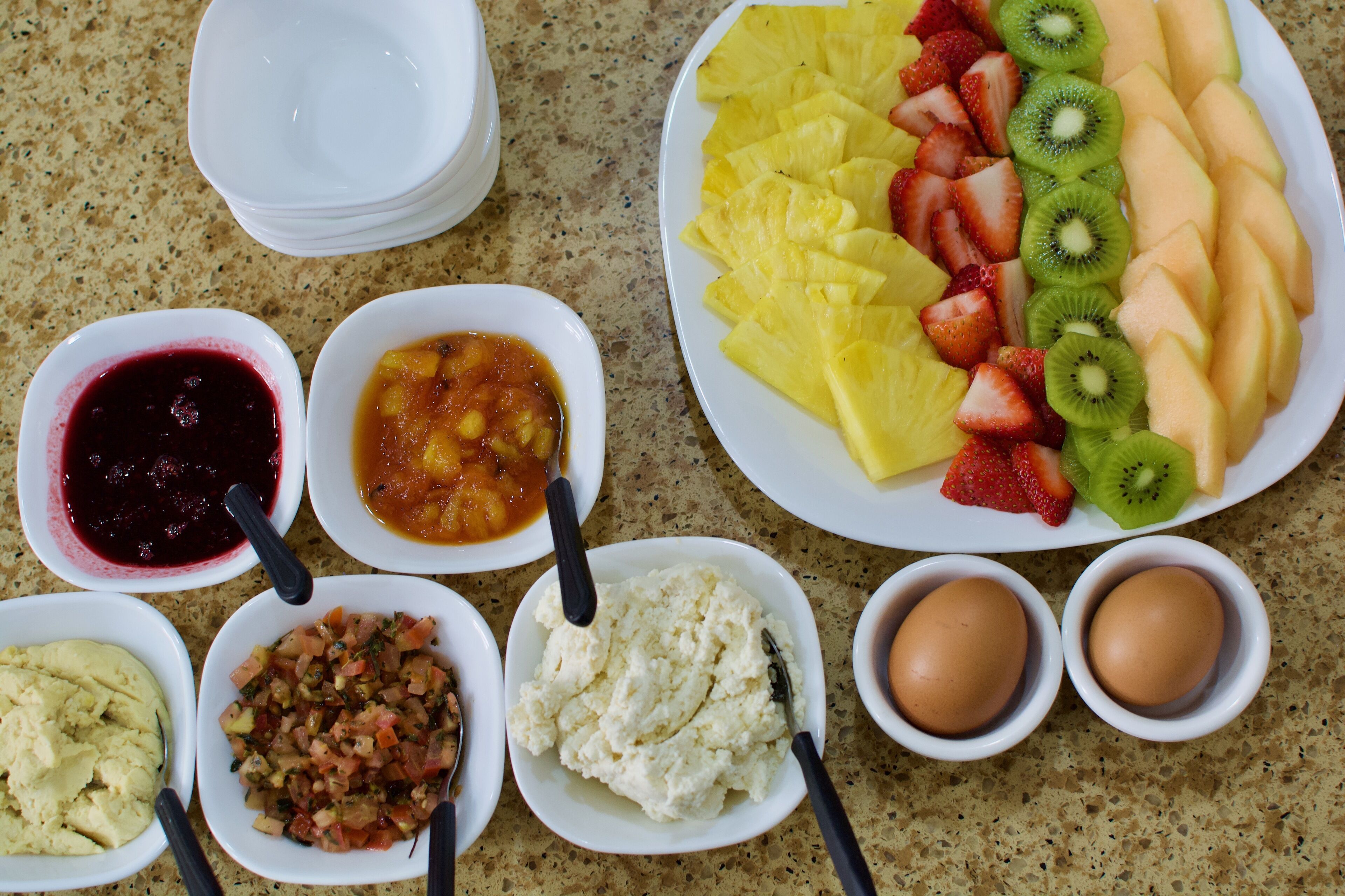 Diversos alimentos, incluindo frutas, legumes e ovos, sobre uma bancada.