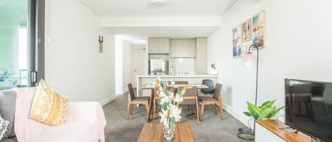 Uma sala de estar moderna com sofá, mesa de centro e aparador para TV.