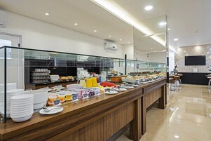 Disposição de buffet com diversos alimentos e pratos.