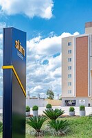 Um hotel moderno com uma placa de destaque que diz 'Slim Hotels'.