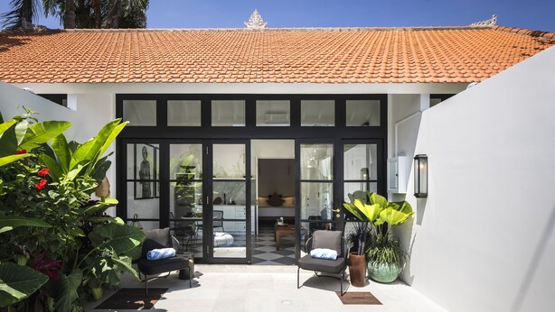 Uma casa moderna com piscina, janelas amplas e área de estar externa.