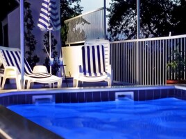 Uma área de piscina com espreguiçadeiras e uma cerca.