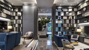 Uma sala de estar moderna com uma escadaria central, estantes embutidas e áreas de estar.