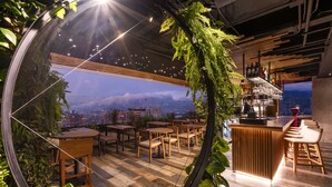 Um espaço de bar moderno com piso de madeira, balcão e assentos.