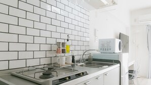 Cozinha moderna com armários brancos, fogão de aço inoxidável e micro-ondas.