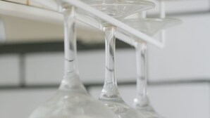 Close-up de taças de vidro transparente sobre uma prateleira branca.