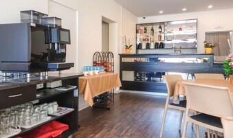 Um café moderno com máquina de café, área de estar e variedade de bebidas.