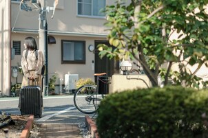Uma pessoa com mala e bicicleta em ambiente urbano ao ar livre.