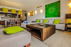 Uma sala de estar moderna com sofá, mesa de centro e um espaço de jantar com cadeiras e mesa.