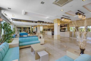 Um hall amplo com áreas de estar, um balcão de recepção e vista para a área comercial.