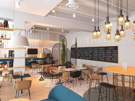 Interior moderno de café, com quadro de cardápio, disposição de assentos e iluminação pendente.