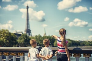Vista da Torre Eiffel a partir de uma ponte com guarda-corpo.