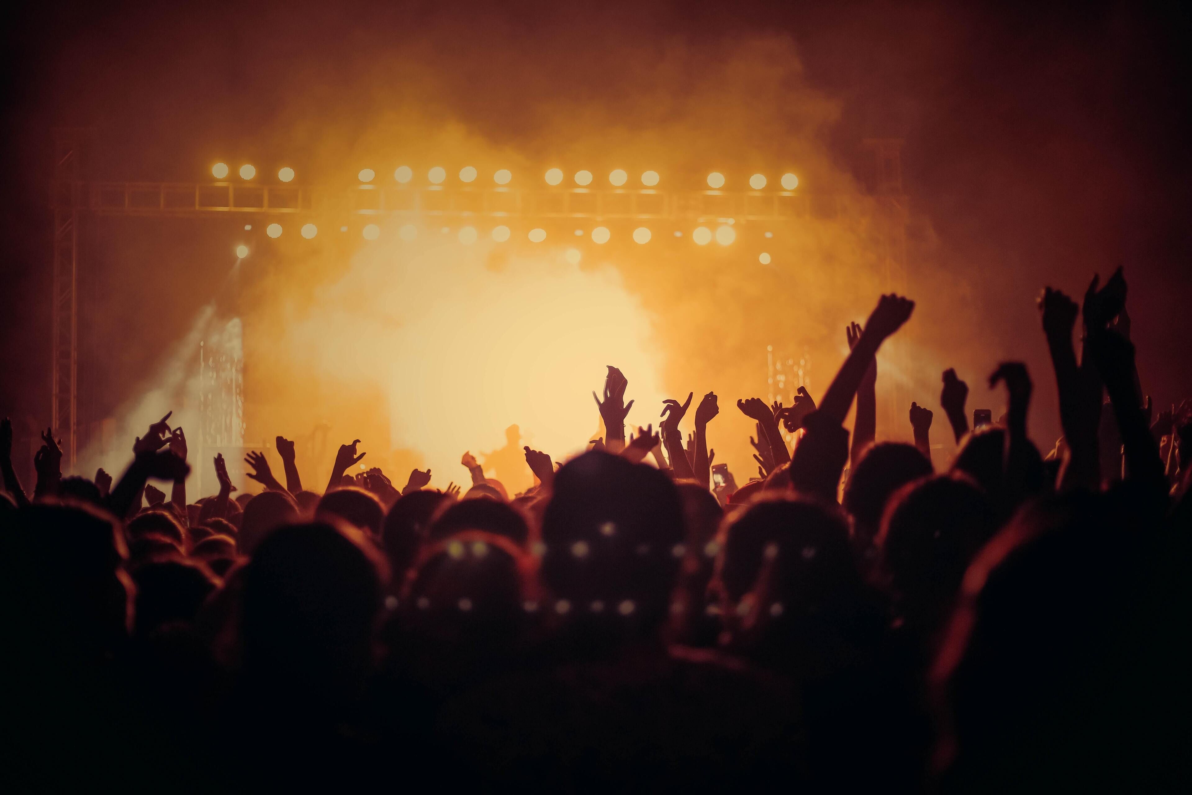 Um concerto com uma multidão de pessoas e iluminação de palco.