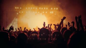 Um concerto com uma multidão de pessoas e iluminação de palco.