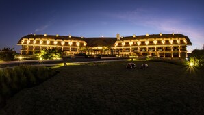 Um hotel grande e iluminado, com vários andares e uma entrada bem iluminada.