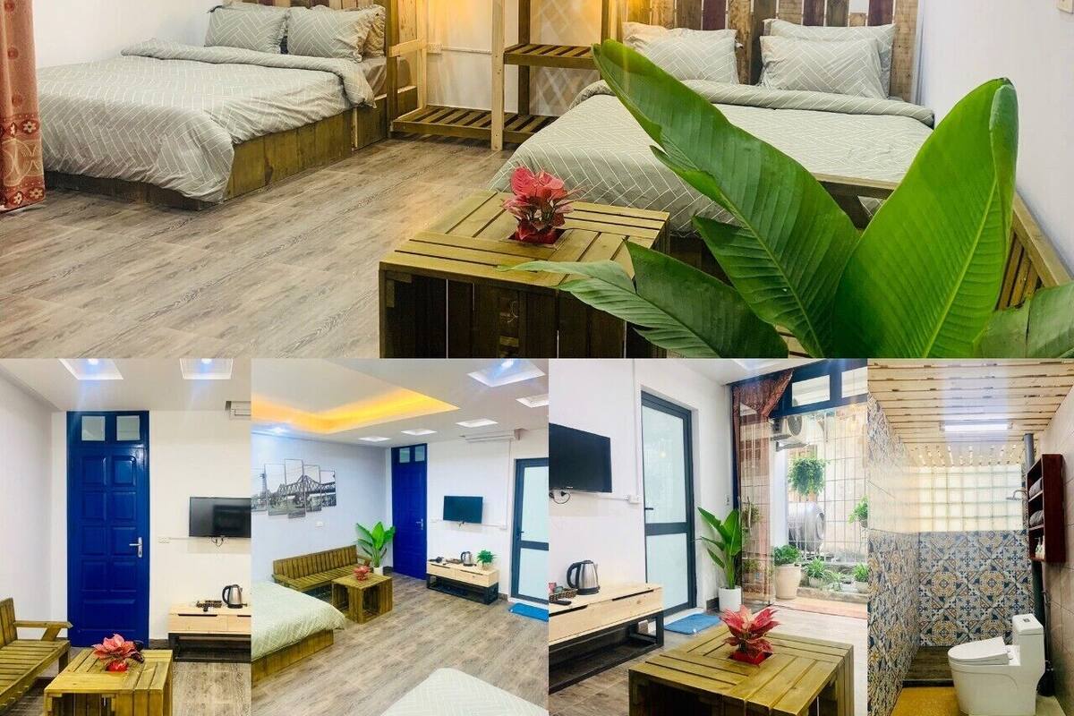 Quarto de hotel com cama, escrivaninha, cadeira, televisão e banheiro.