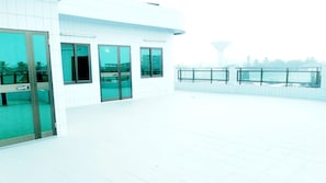 Um edifício moderno com janelas amplas e um terraço no telhado.