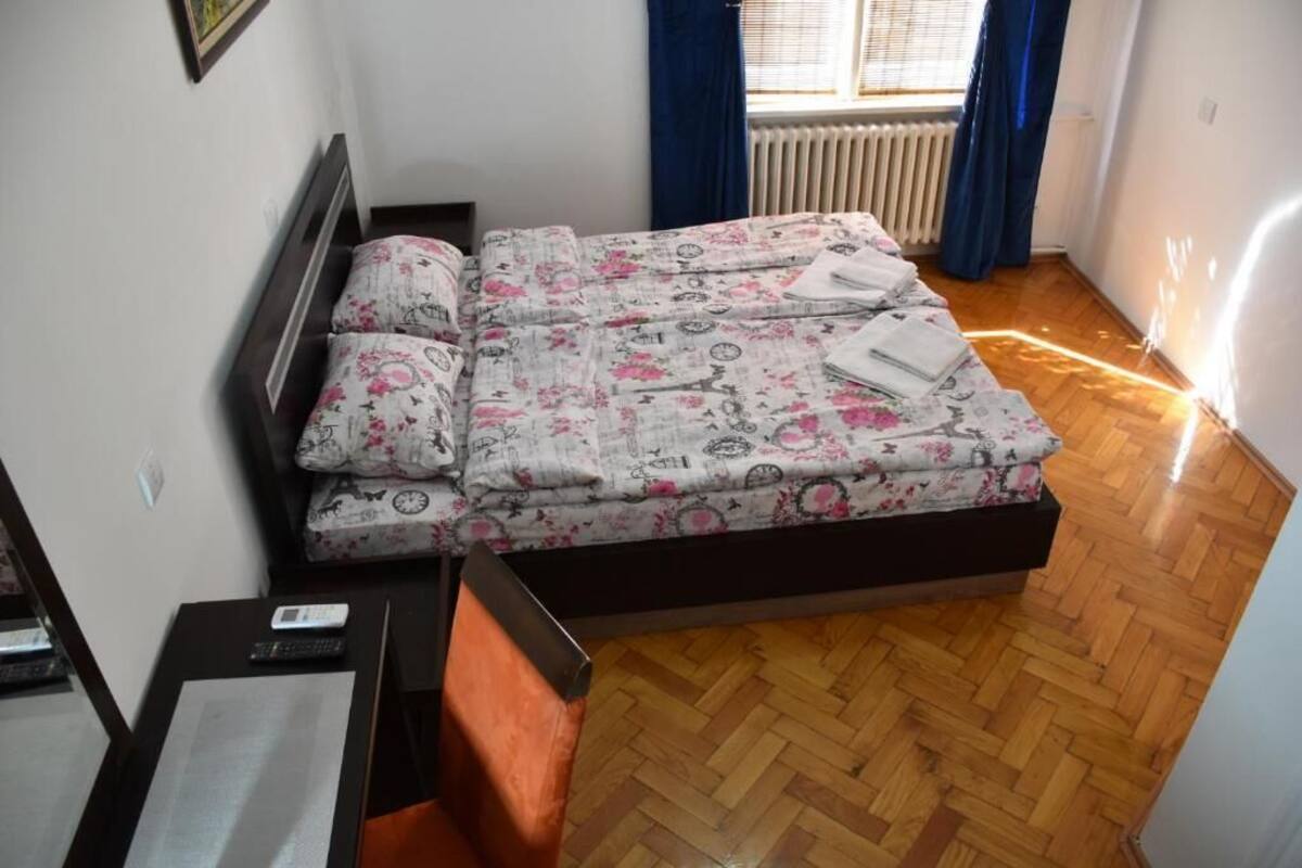 Um quarto com uma cama, uma escrivaninha e uma cadeira.