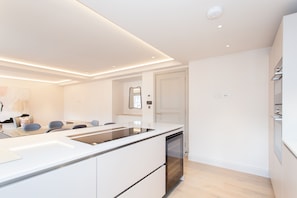 Apartamento, 3 quartos | Cozinha privada | Geladeira grande, micro-ondas, fogão, cooktop