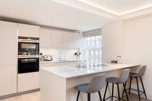 Apartamento, 3 quartos | Cozinha privada | Geladeira grande, micro-ondas, fogão, cooktop