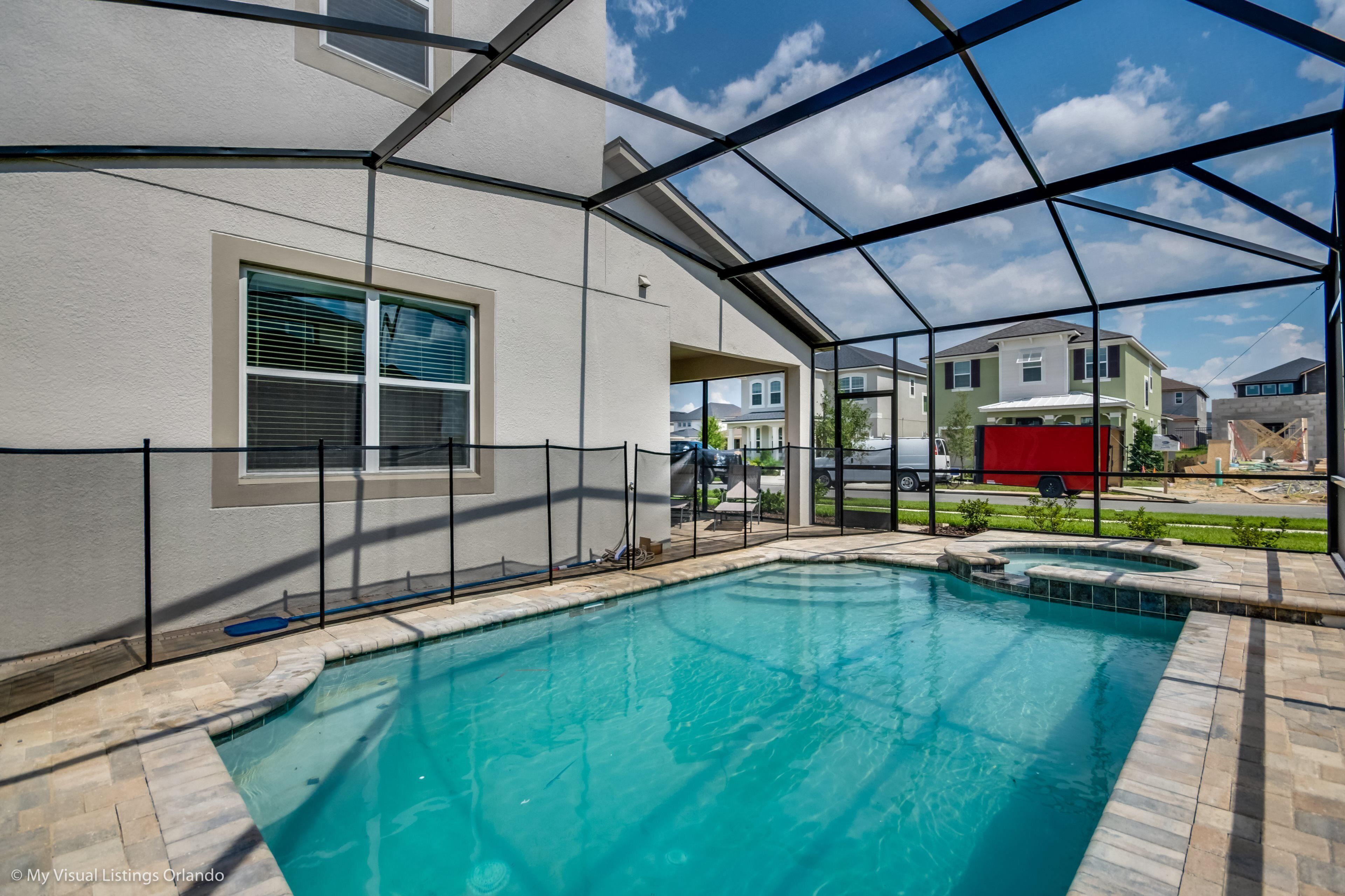 Piscina com vista clara das casas ao redor e área cercada.