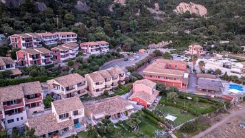 Zona residencial com edifícios altos, piscina e rua.