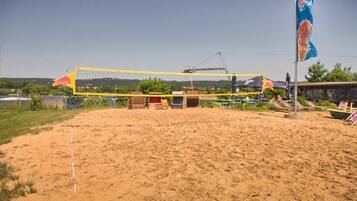 Uma quadra de voleibol com rede, bandeira e mastro.