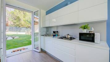 Vila família, vários quartos, 2 banheiros, ao lado da montanha (Villa Il Gelsomino Bellavista) | Cozinha privada | Geladeira grande, micro-ondas, fogão, cooktop