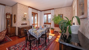 Uma sala de jantar com mesa de madeira, cadeiras e papel de parede floral.
