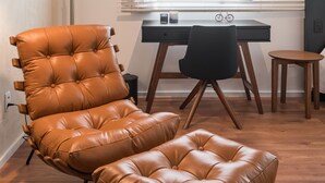 Uma sala de estar moderna com uma poltrona de couro, uma escrivaninha e uma bicicleta.