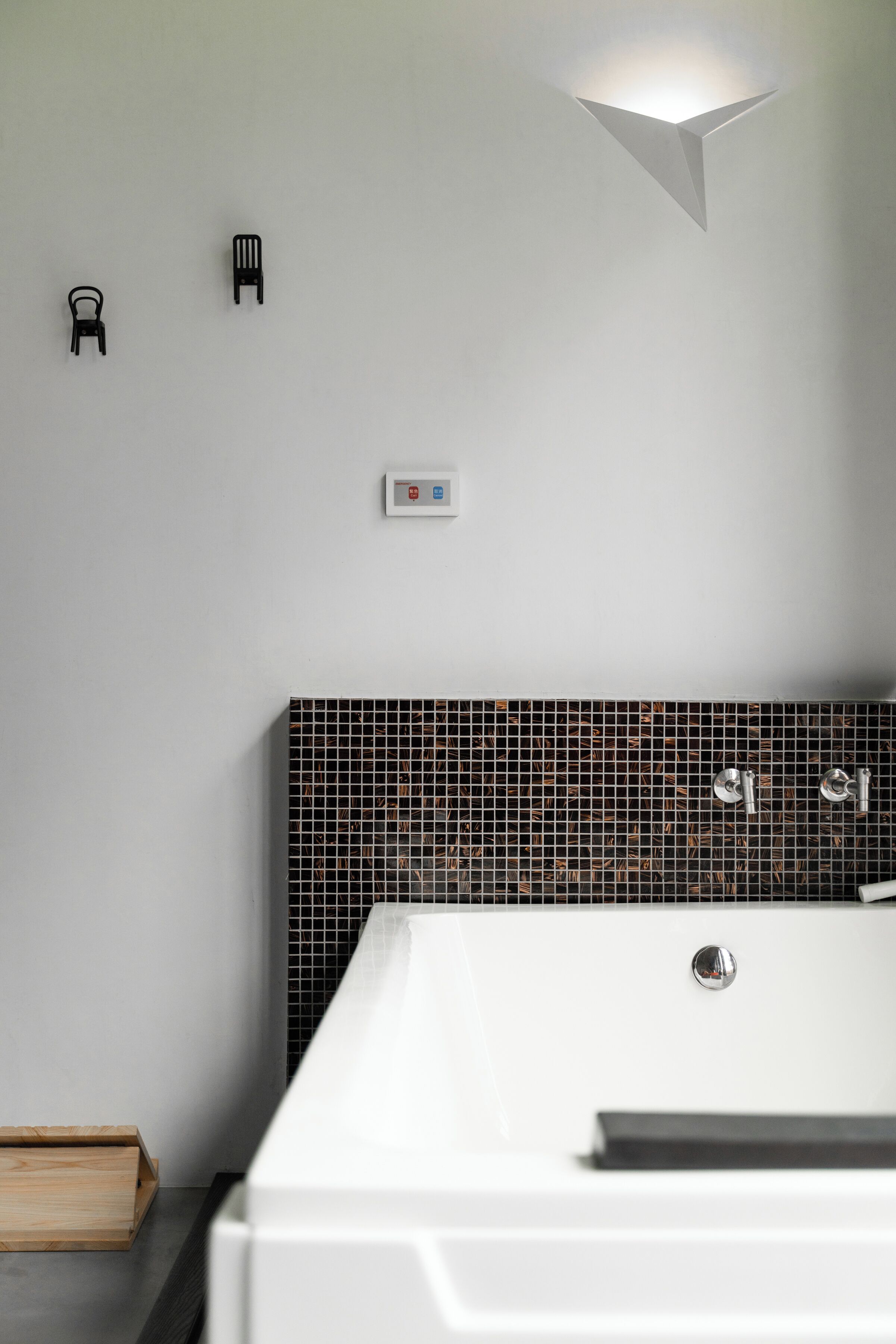 Um banheiro moderno com uma banheira grande, aquecedor fixado na parede e painel de controle.
