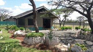 Uma casa com telhado inclinado, porta da frente e um pequeno alpendre.