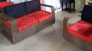 Acomodação em tenda com móveis de vime e mosquiteiro.