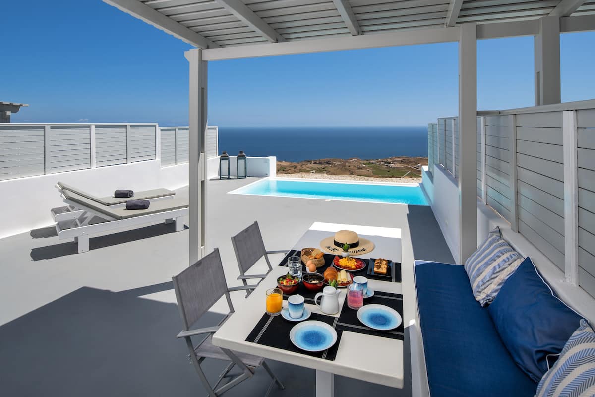 Terraço com piscina, mesa de jantar e área de estar com vista para o mar.