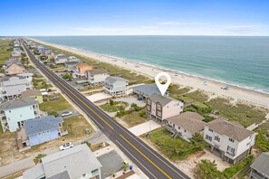 Uma área residencial à beira-mar, com casas, uma estrada e uma praia.